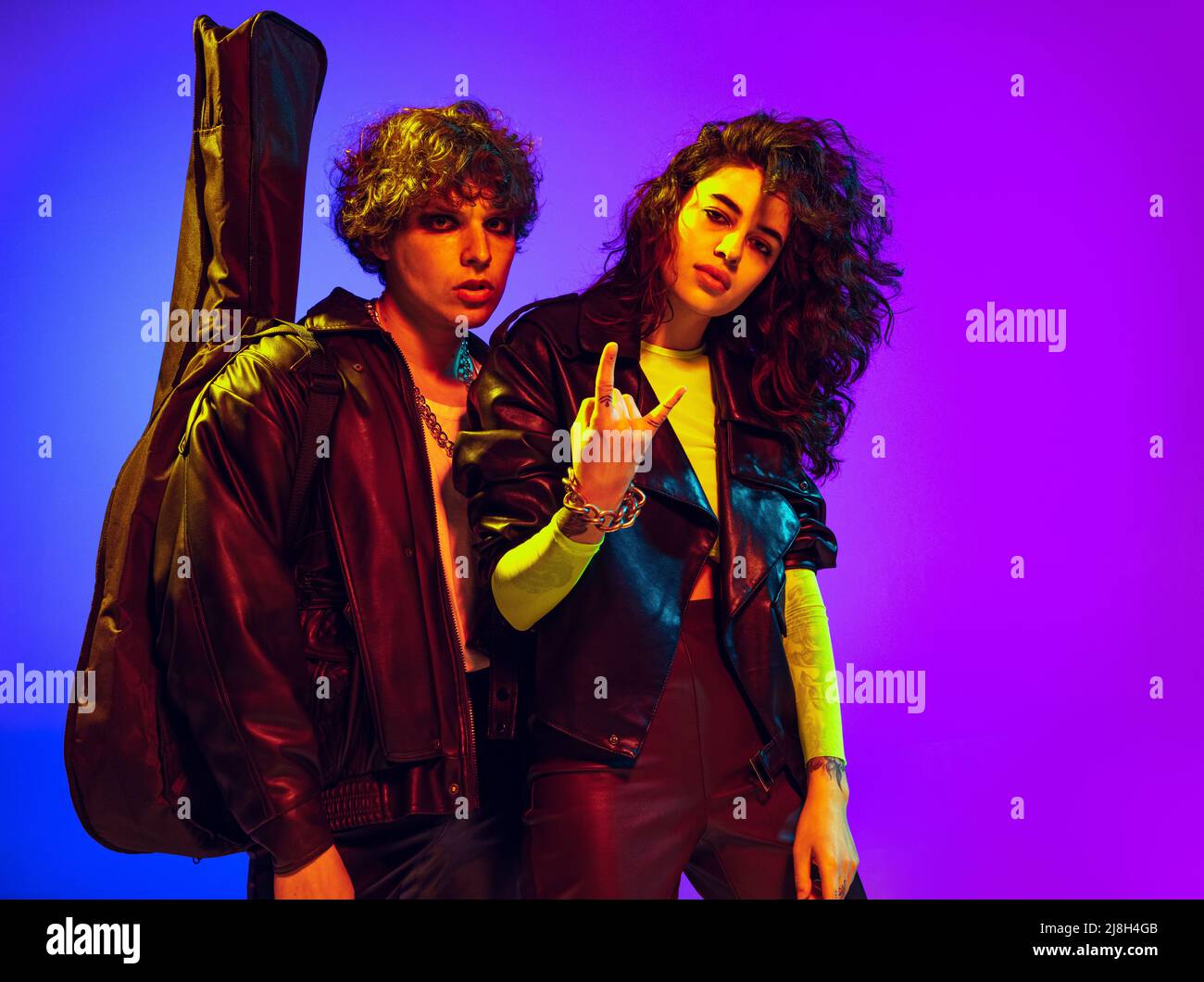 Young couple of rock-and-roll musicians wearing black leather outfits ...