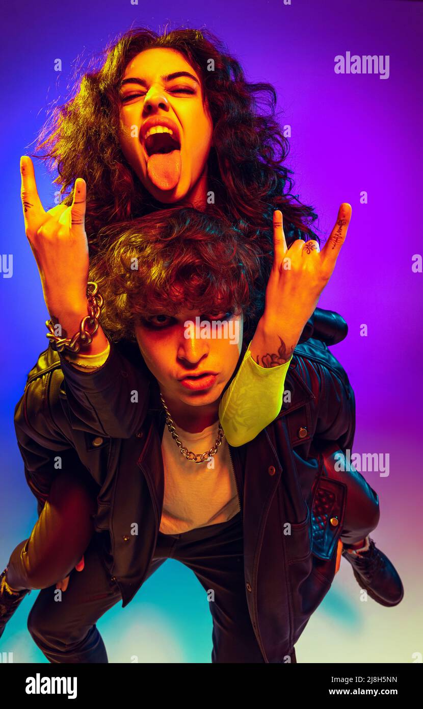 Rock music fans. Excited young man and girl in black leather outfits ...