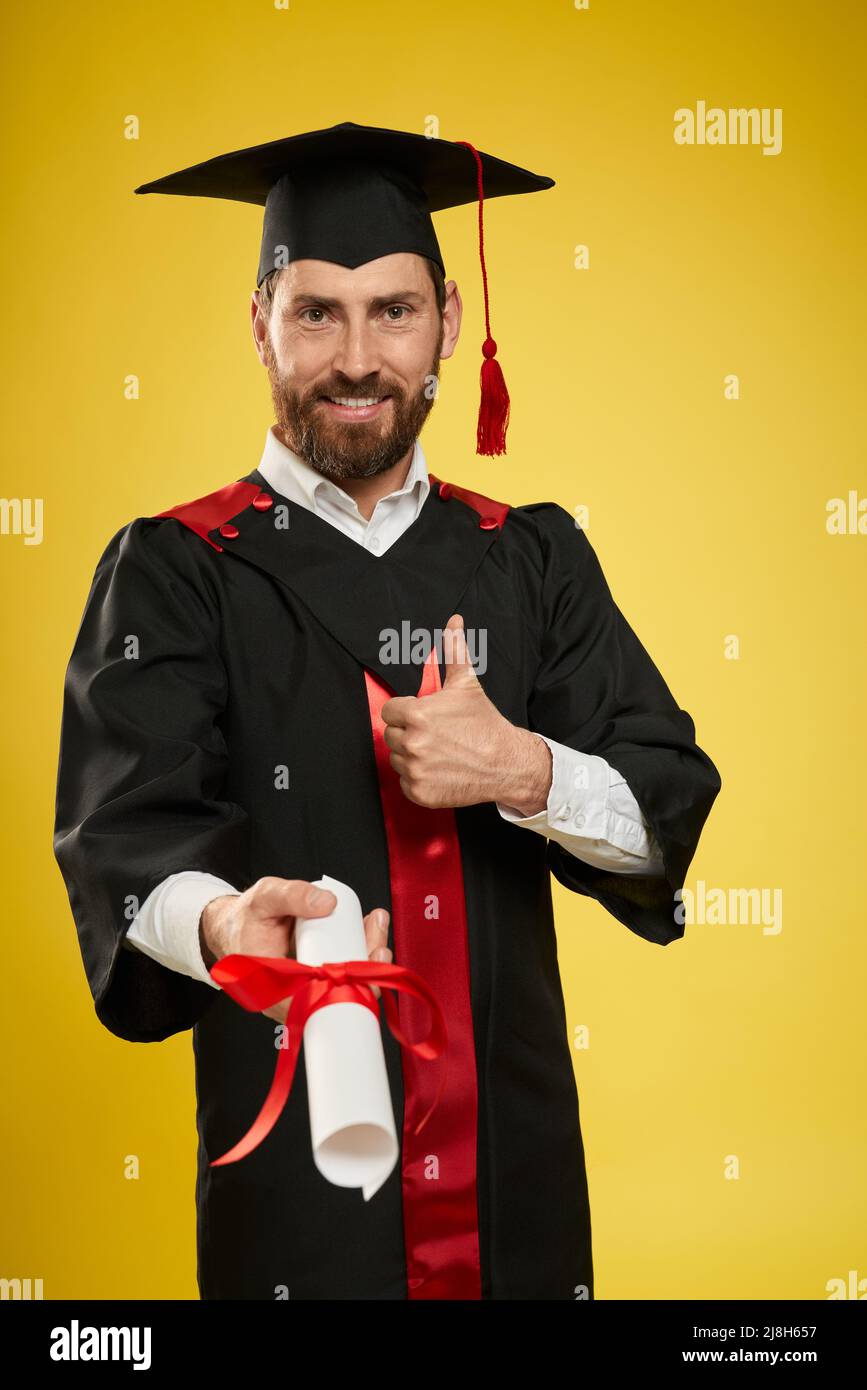 Front view of cheerful, proud student holding diploma, showing super ...