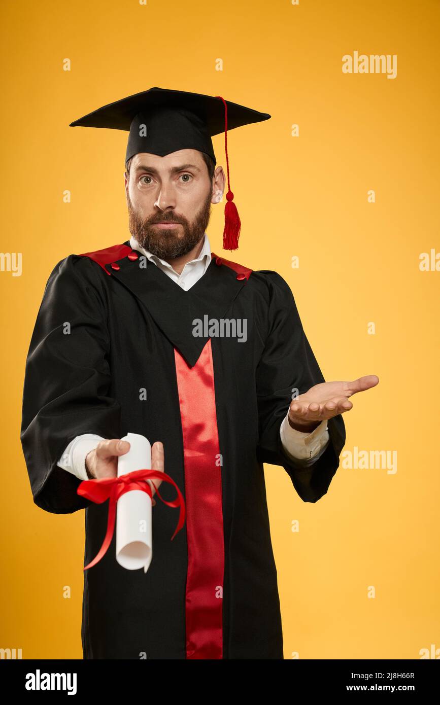 Front view of young male holding, showing diploma, asking. Handsome man ...