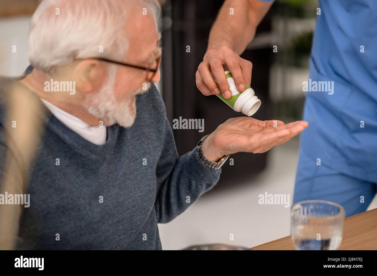 Elderly person receiving a medication from the pill bottle Stock Photo ...