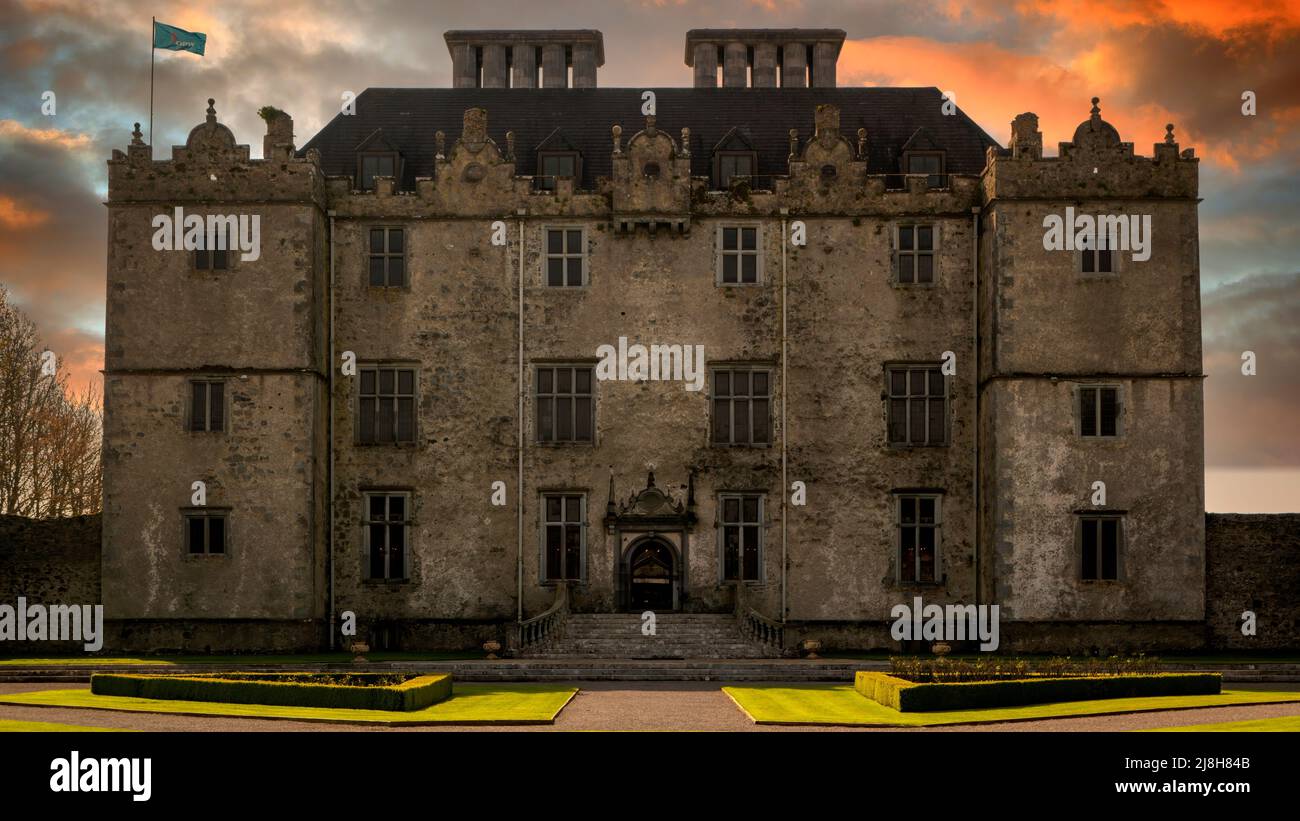 Image of a building of an old Irish castle against colorful clouds of ...