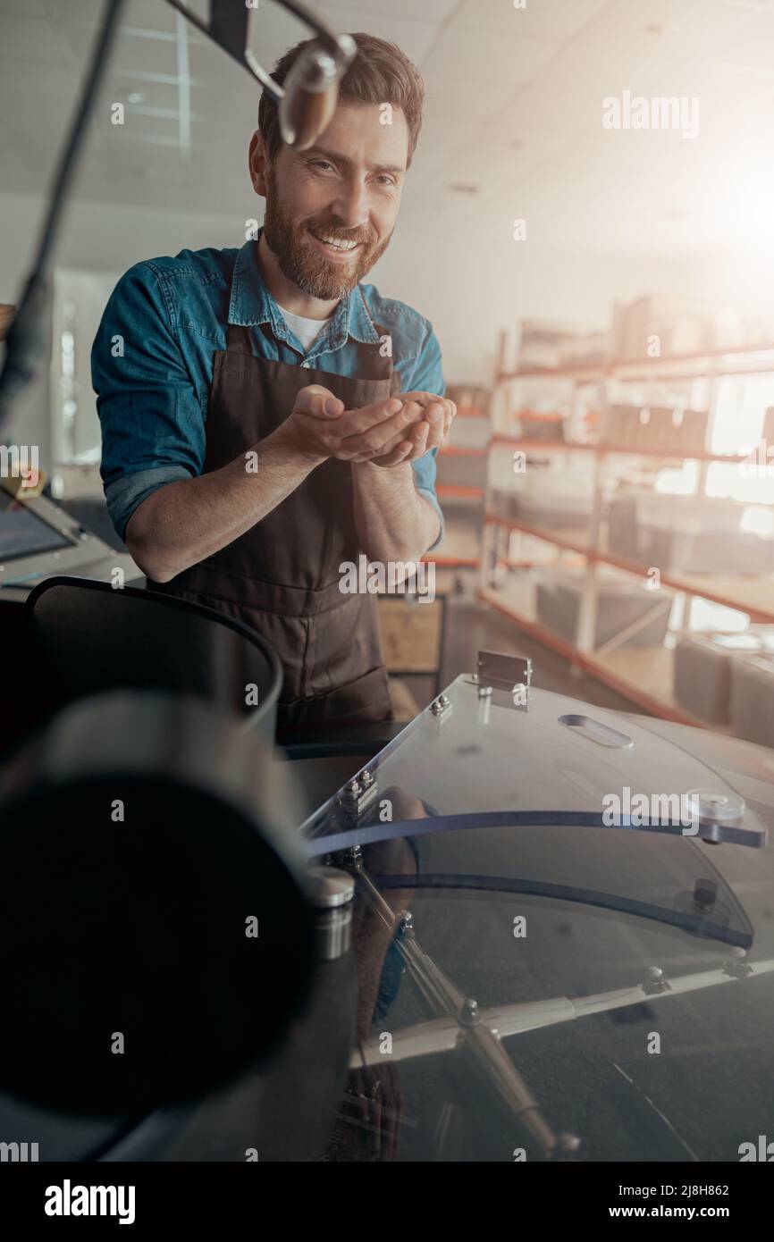 Business owner in uniform inhaling the aroma of coffee in own ...