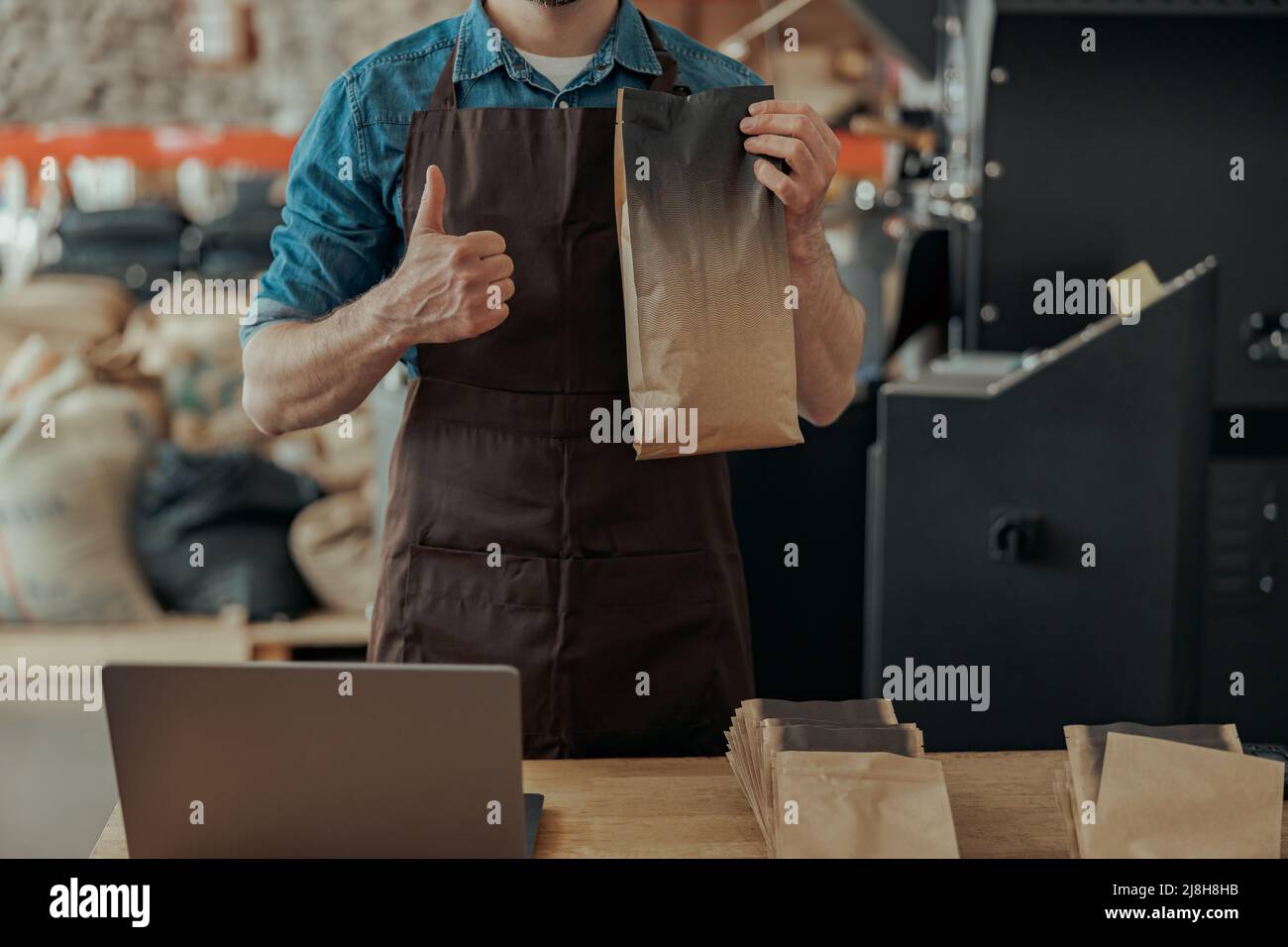 Close up of business owner hands holding roasted coffee beans in paper ...