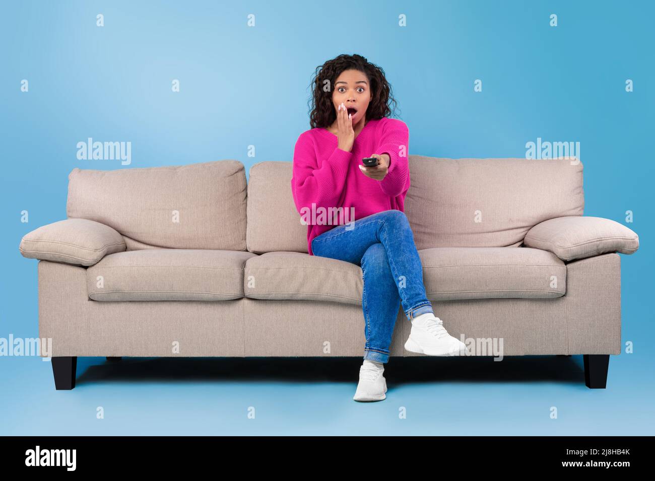 Scared woman on sofa watching tv hi-res stock photography and images ...