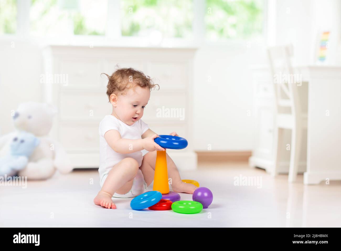 Baby playing with colorful toys. Educational toy stack for young child ...