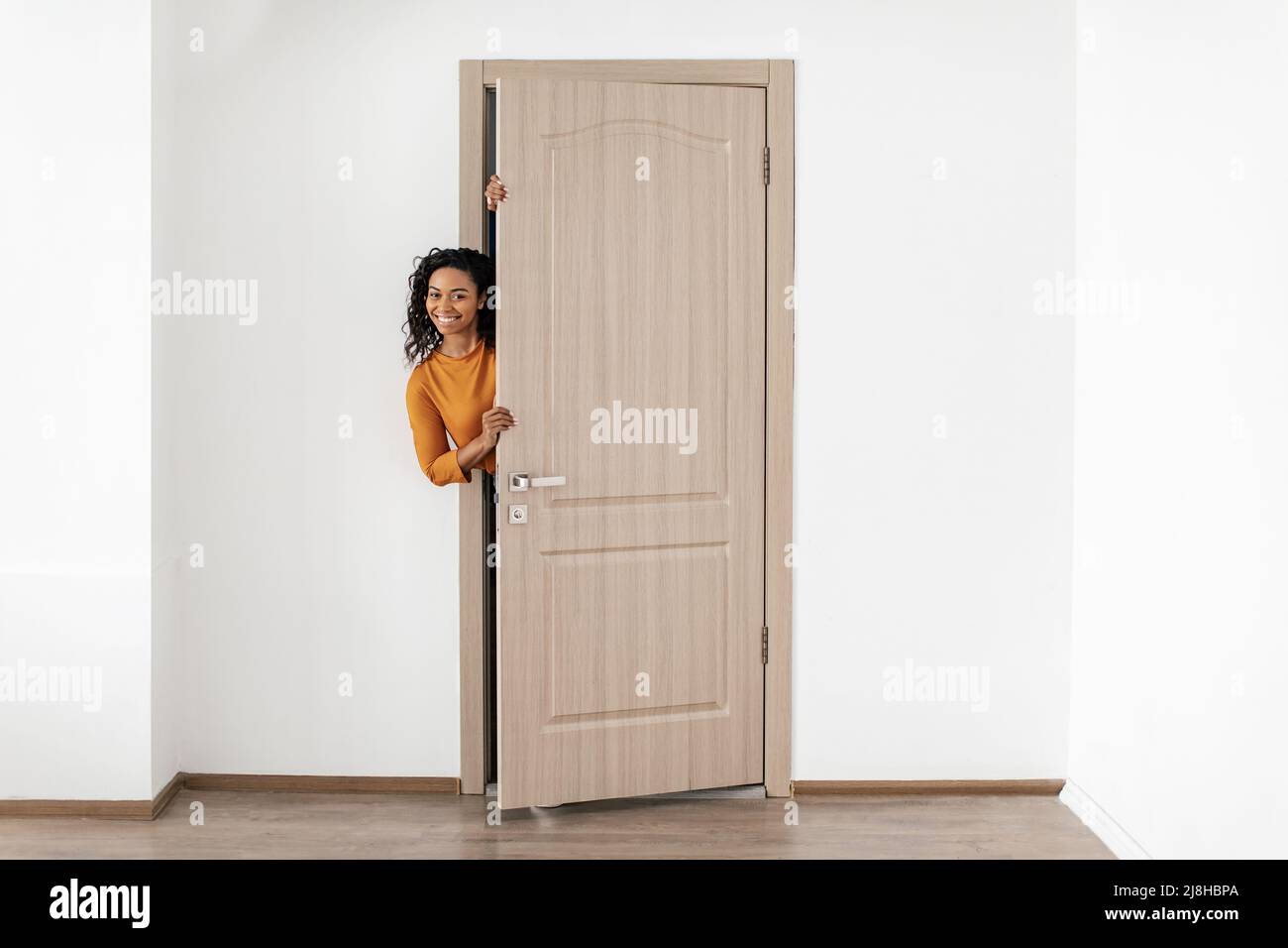 Cheerful African American Woman Opening The Door Smiling Standing ...
