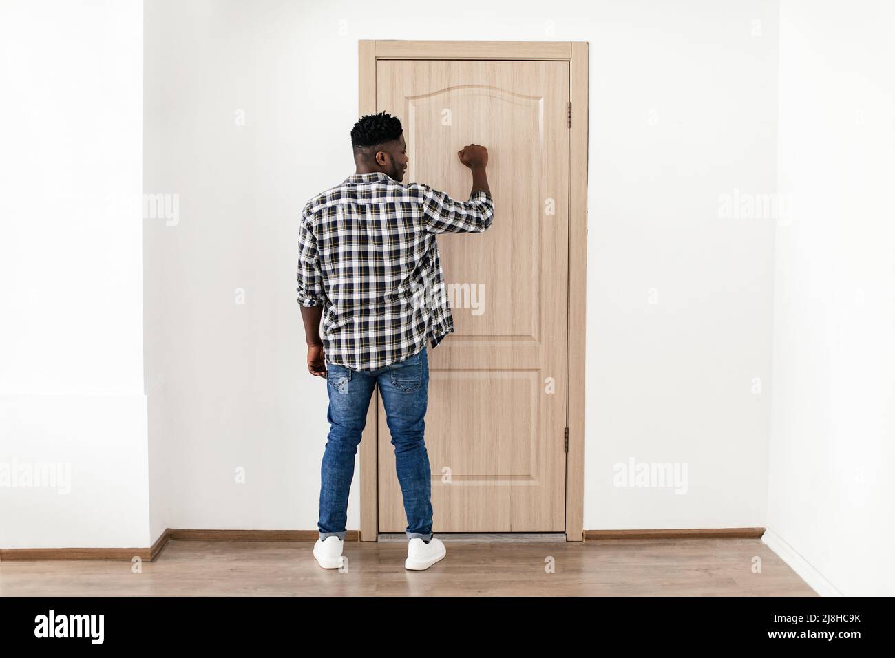 Back View Of African American Man Knocking At Door Indoor Stock Photo ...