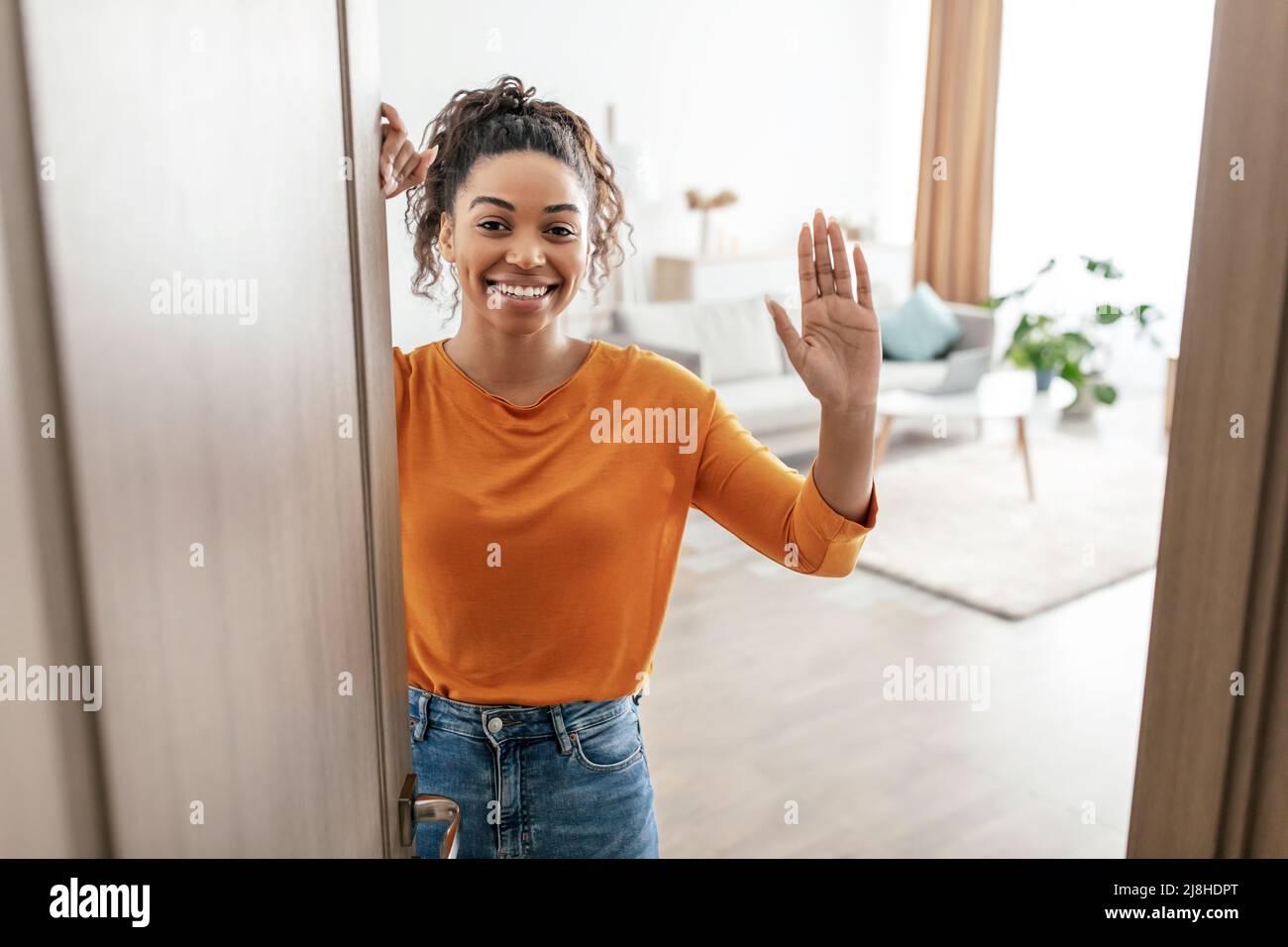 Cheerful Black Female Opening Door Of House Waving Hand Indoor Stock ...