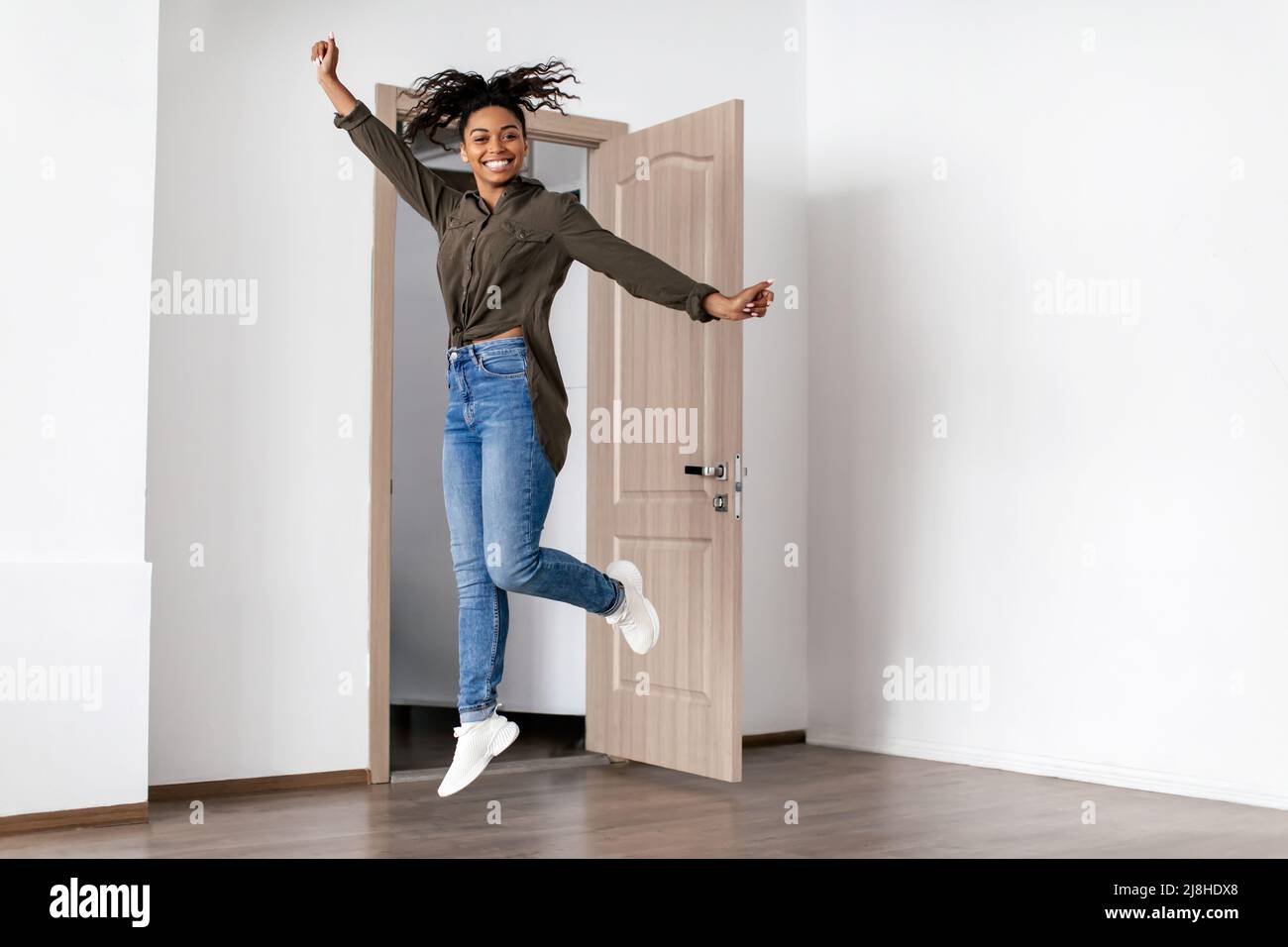 Joyful Black Lady Jumping Near Door Celebrating Moving New Home Stock ...