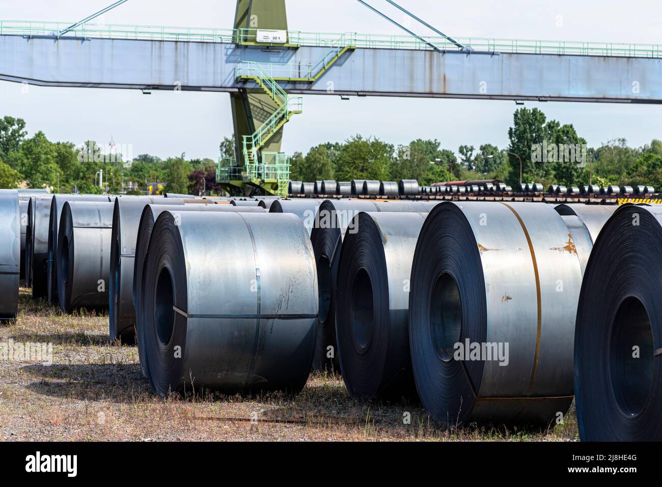 Metal sheets wrapped in large rolls, standing on the loading yard next ...