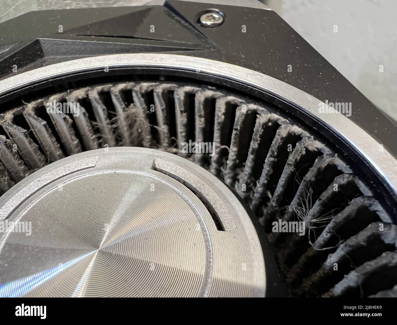 Dust is caked onto the cooling fan of an NVIDIA computer graphics card ...