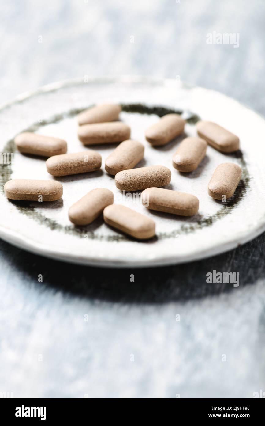 Ashwagandha (Withania somnifera) tablets. Wooden background. Soft focus ...