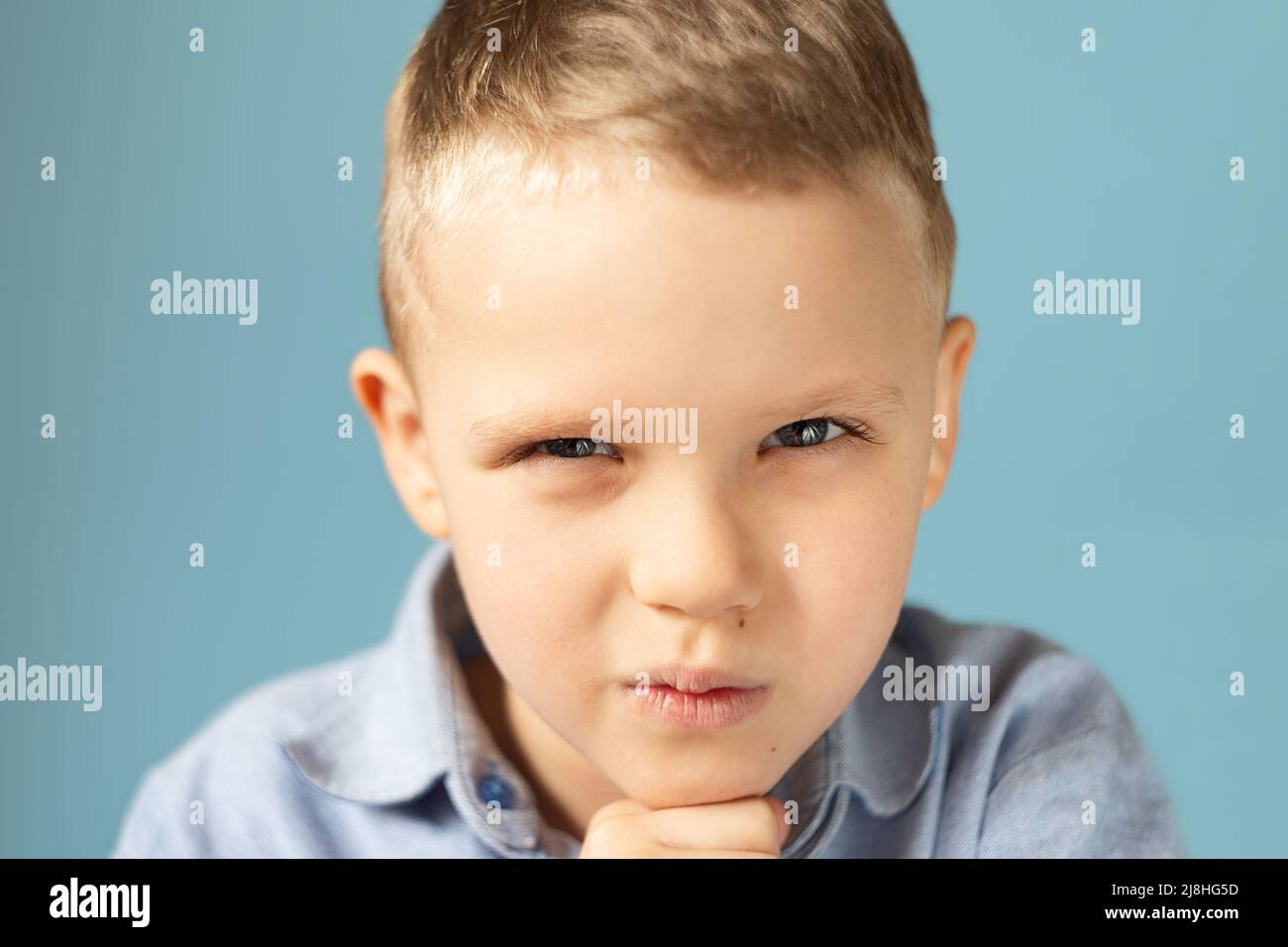 Closeup portrait of cute boy,looks with a squint.Beautiful blue ...