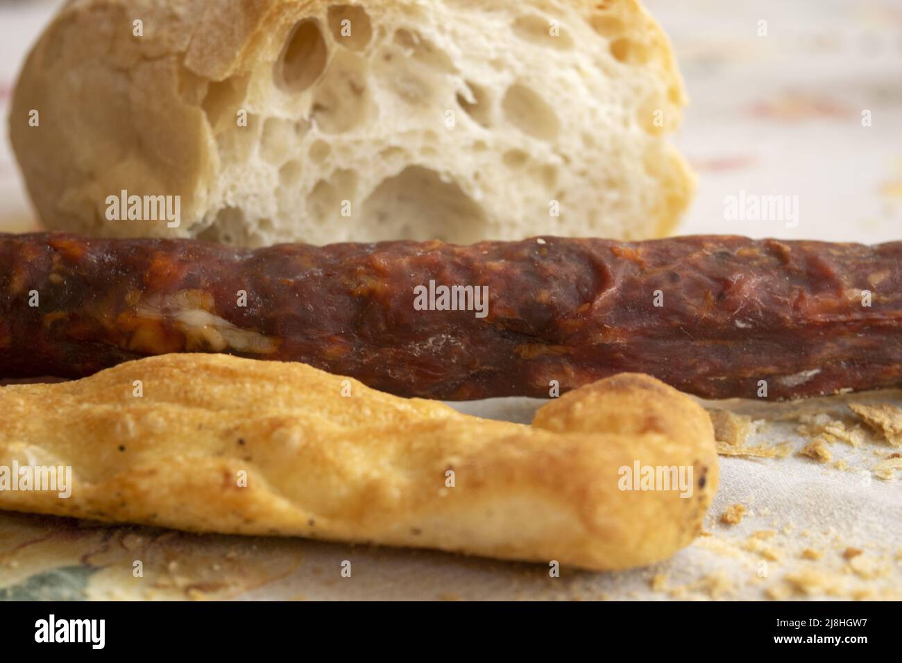 a spicy salami between a bun and a loaf of bread Stock Photo - Alamy