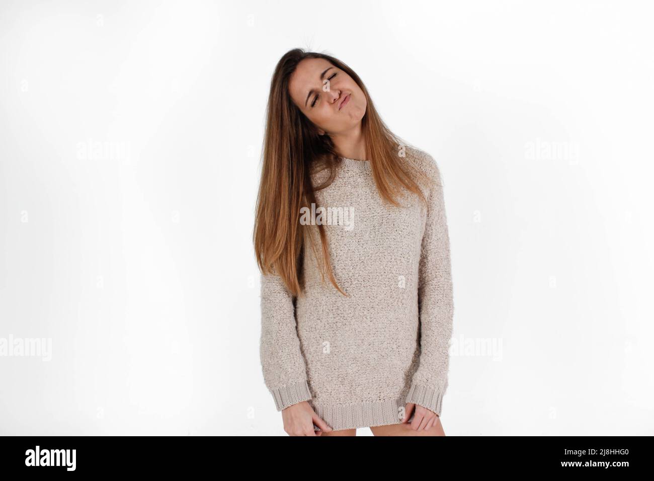 beautiful woman goofing around dressed in a beige and gray dress and ...
