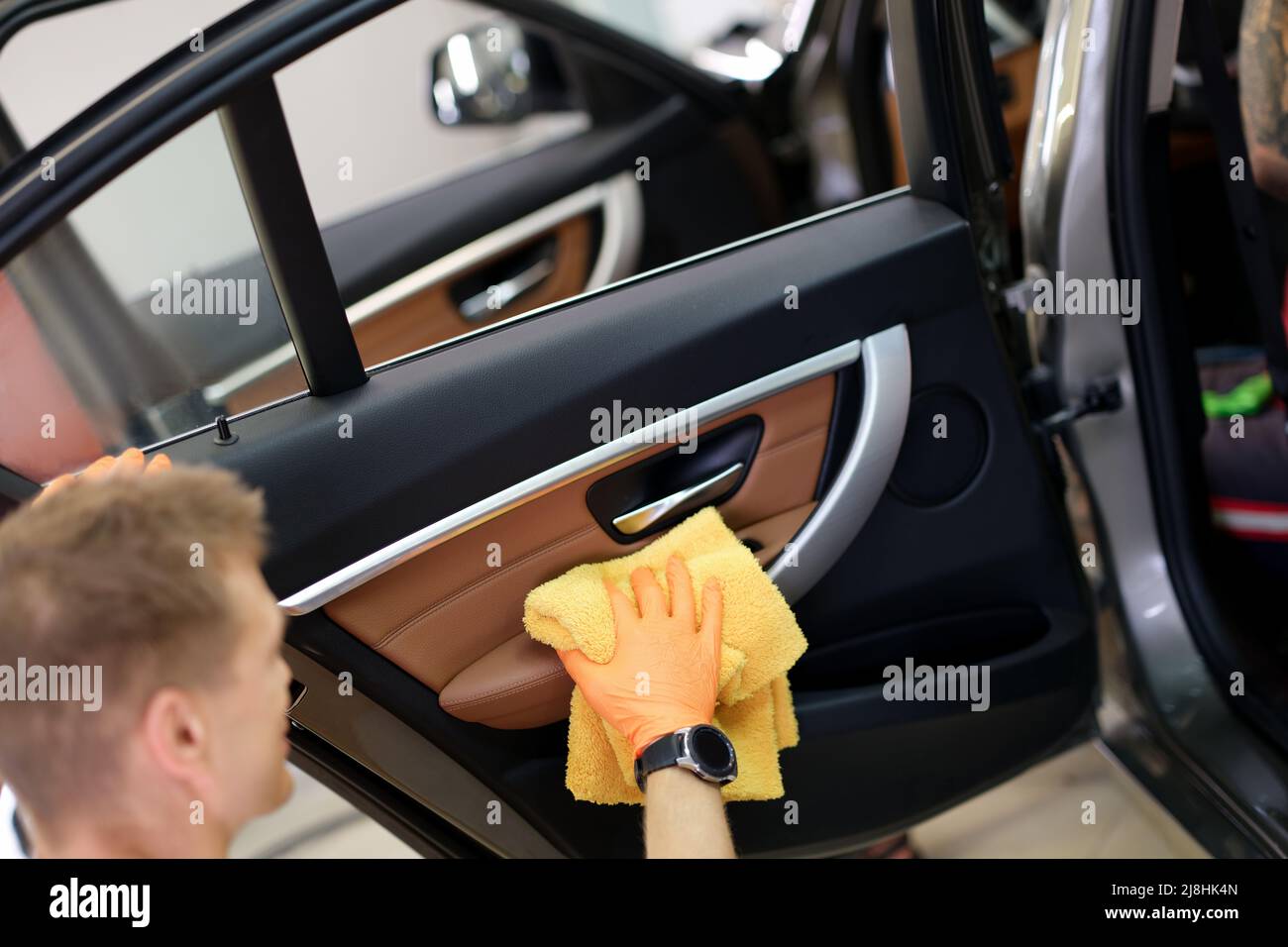 Man cleans car door handle with cloth and car detailing Stock Photo - Alamy
