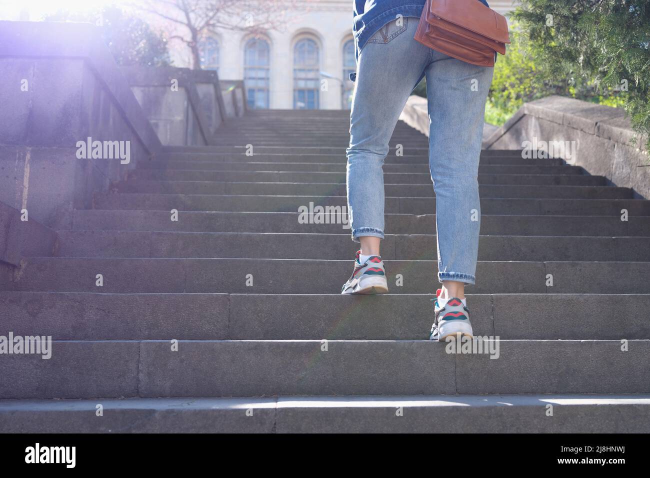 Woman in jeans going up steep stairs Stock Photo - Alamy