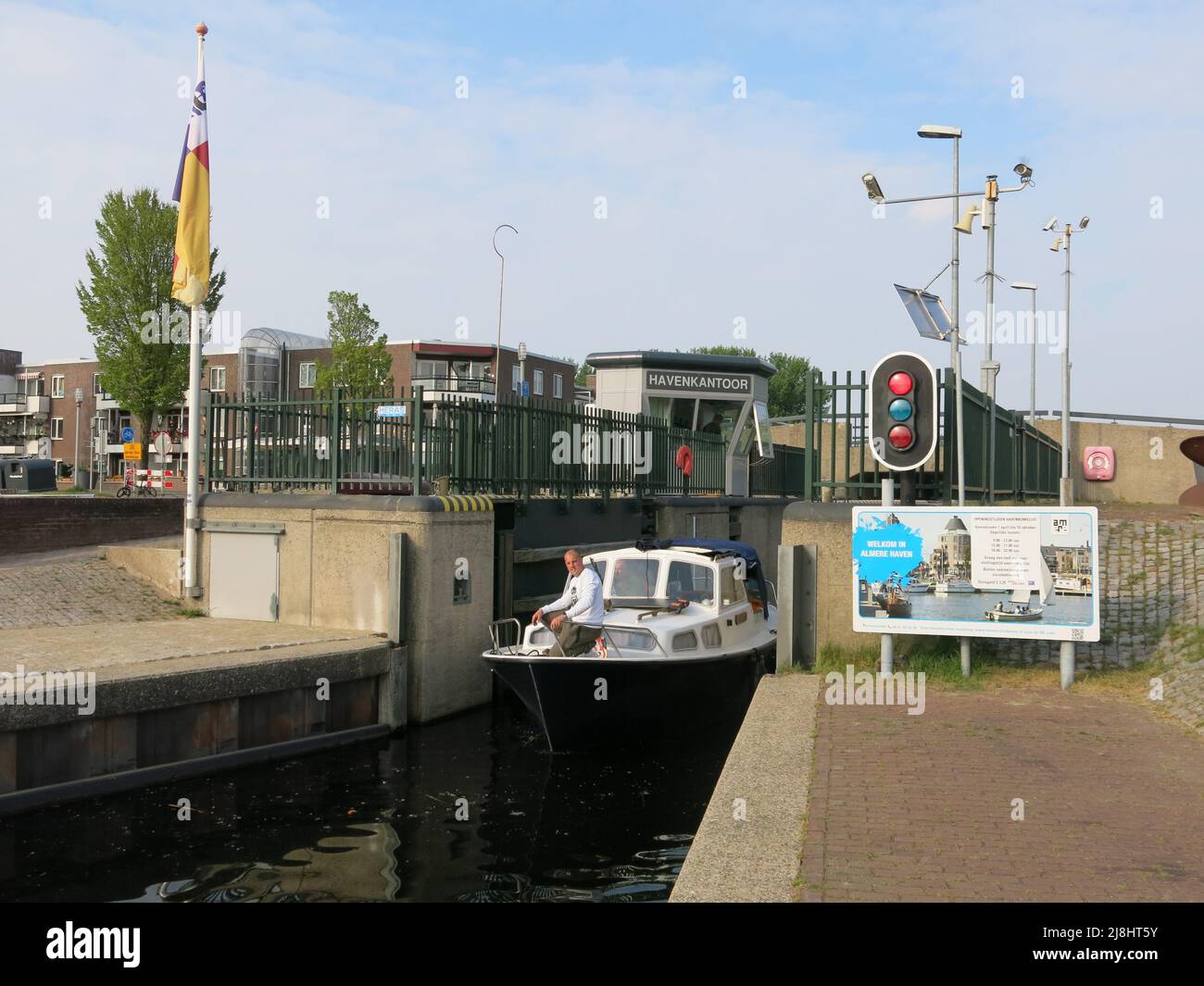 A boat emerges through the automated lock gates at Almere Haven, making ...