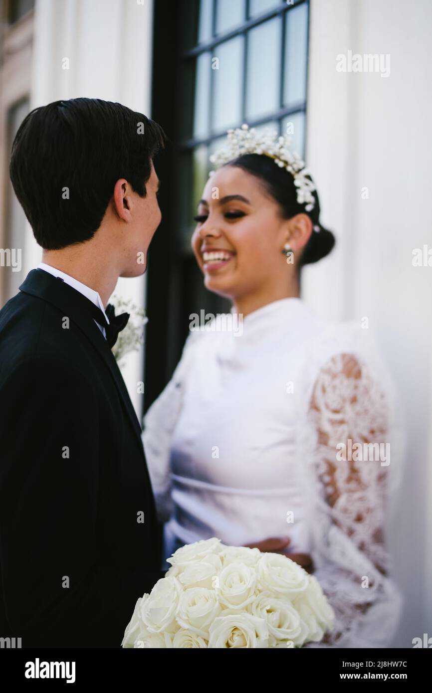Multiracial bride and groom laugh together after wedding ceremony Stock ...