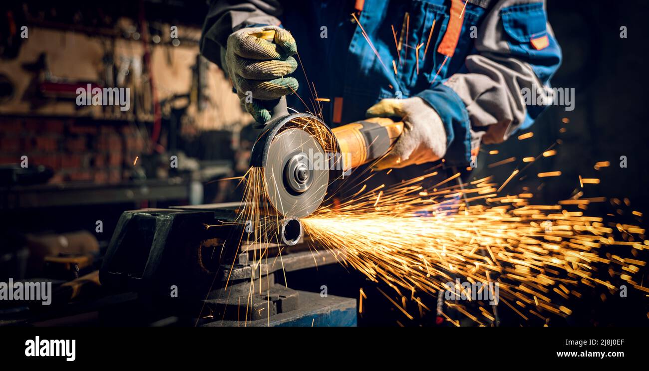 Locksmith in special clothes and goggles works in production. Metal ...