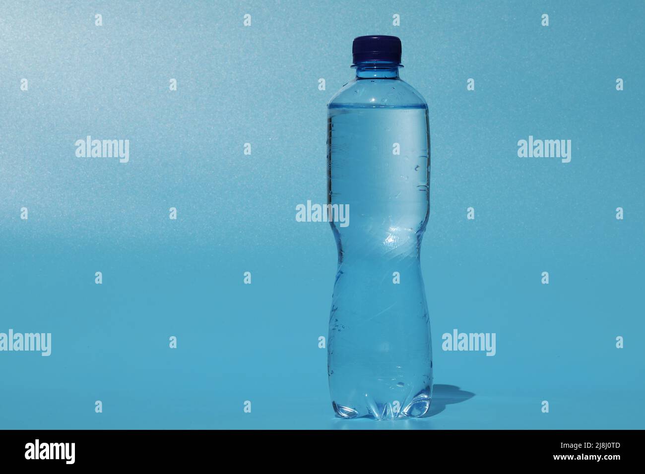 bottle of cold water on the blue background Stock Photo - Alamy