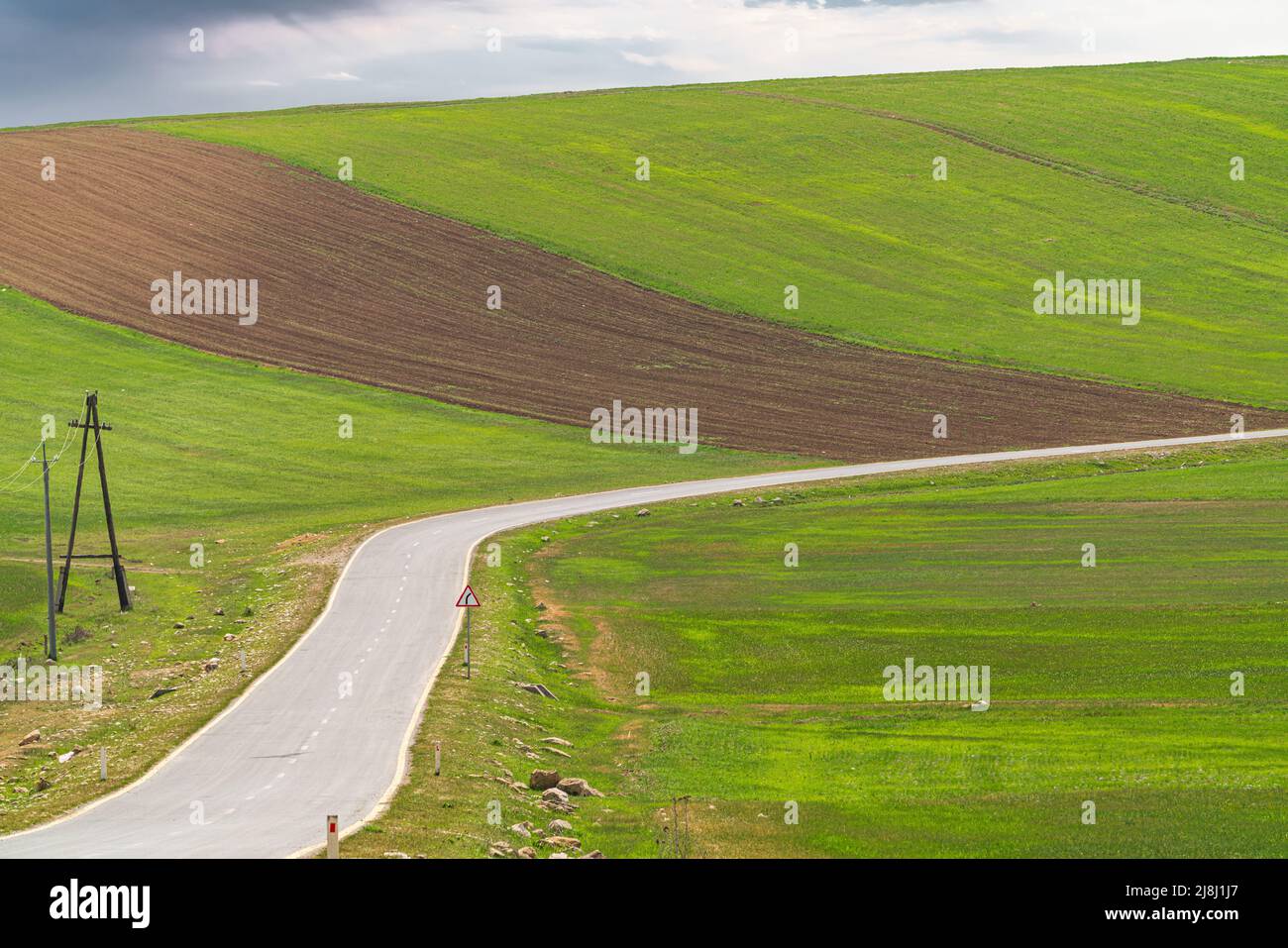 Asphalt road between green farm fields Stock Photo - Alamy