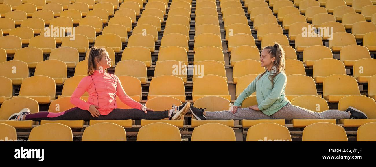 Happy school girls teenagers in activewear do splits stretching legs on ...