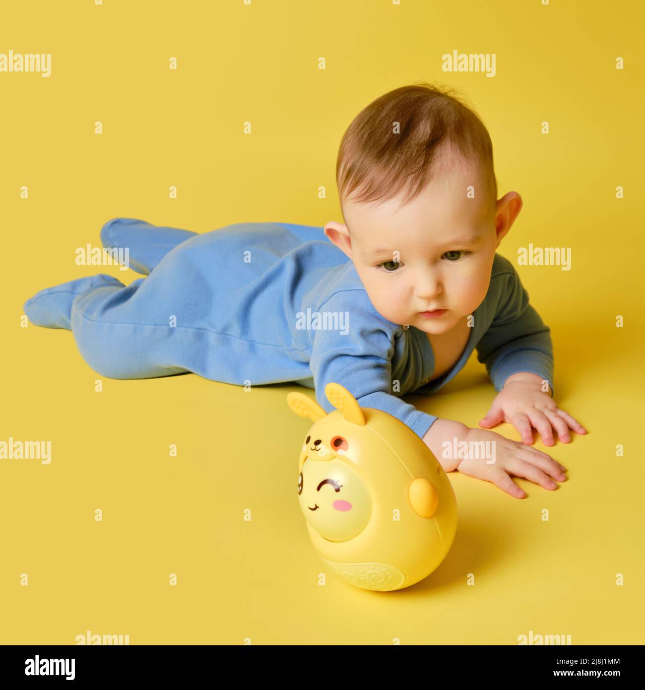Curious toddler baby crawling on studio yellow background. Funny child ...
