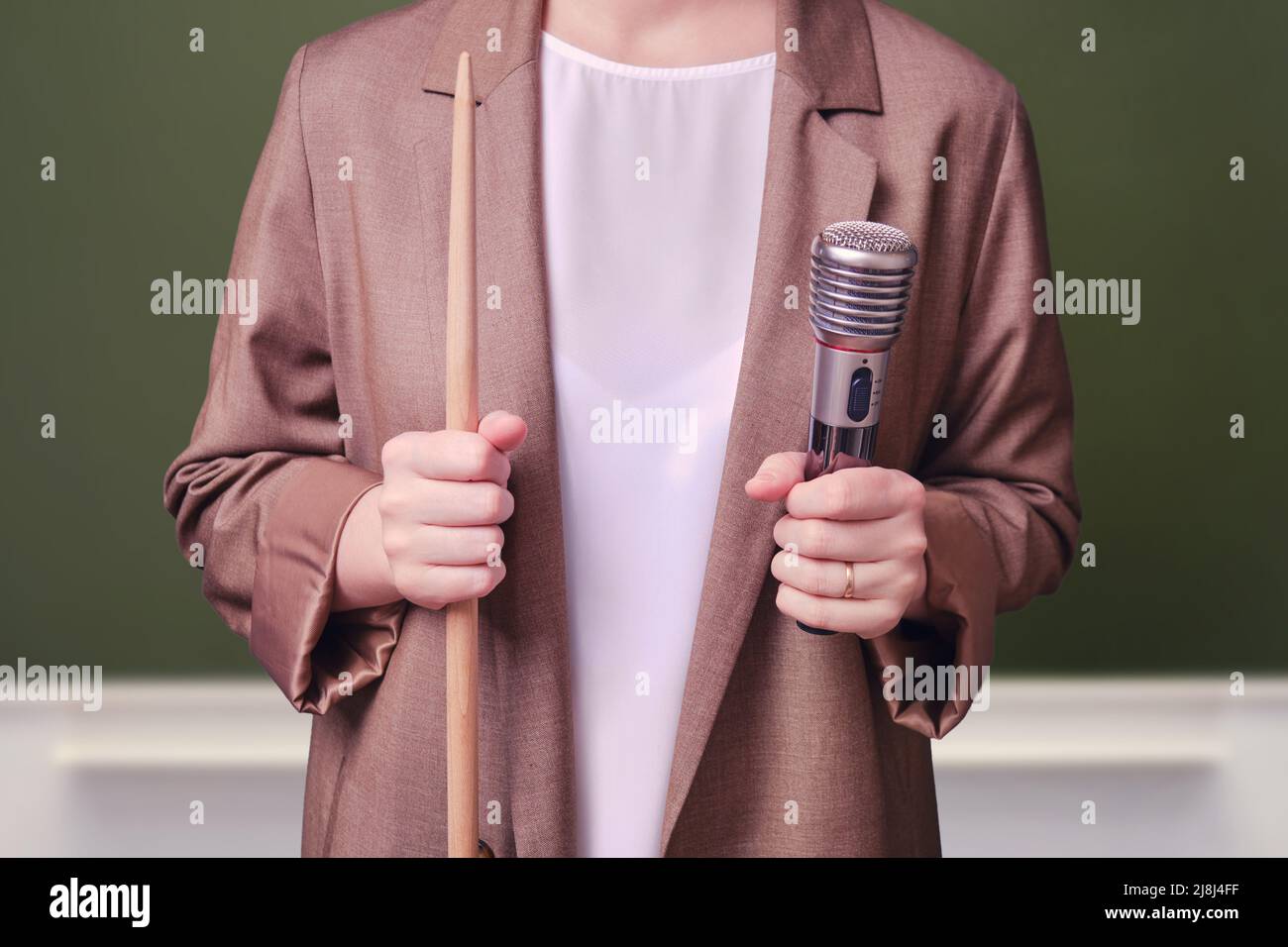 Woman teacher holding microphone in hand on school blackboard in the ...