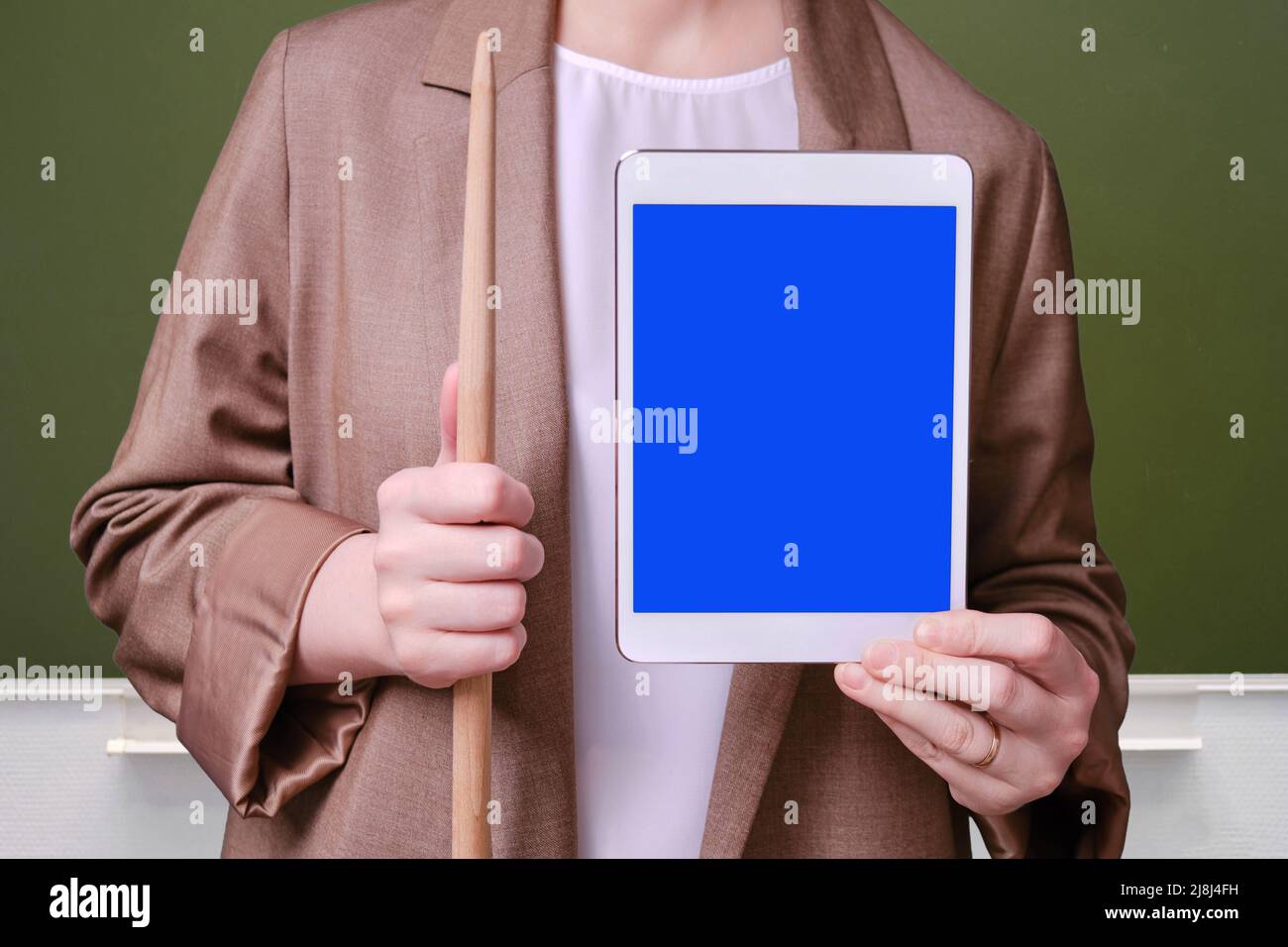 Woman teacher with tablet for online lesson on school blackboard in the ...