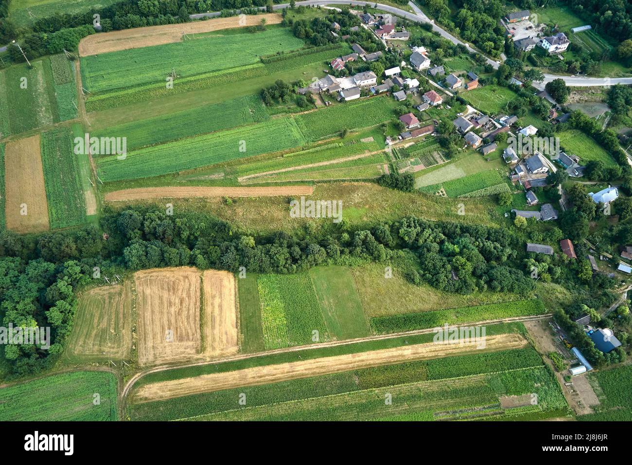 Aerial landscape view of village houses and distant green cultivated ...