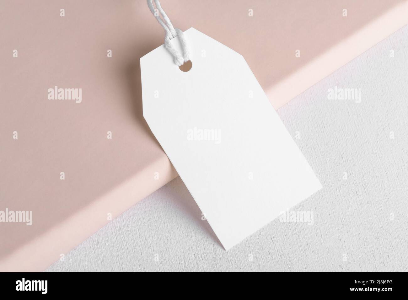 Rectangle white gift tag mockup with white cord, close up on beige and ...