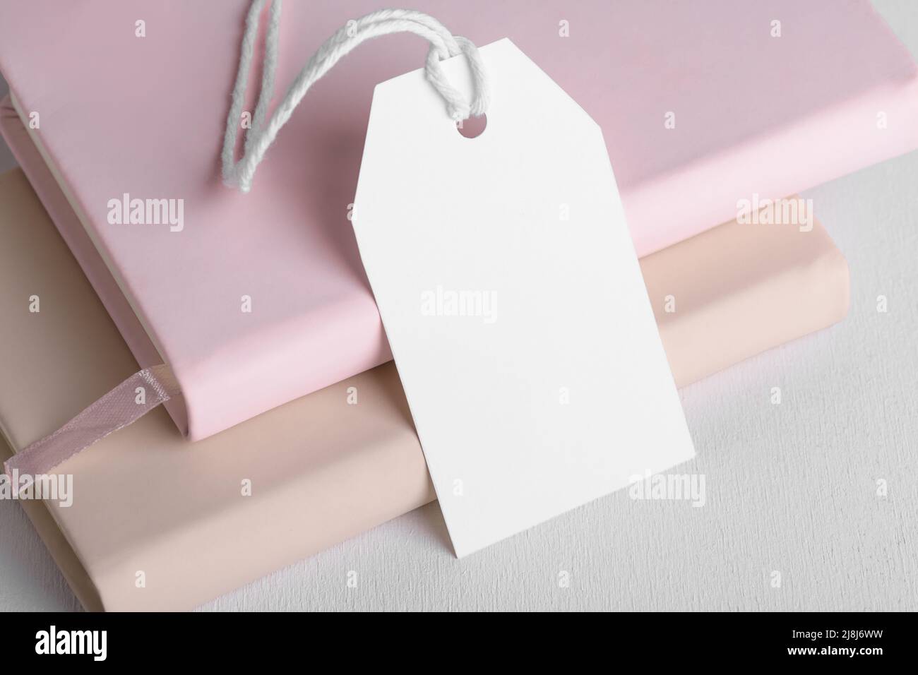 Rectangle white gift tag mockup with white cord, close up on beige and ...