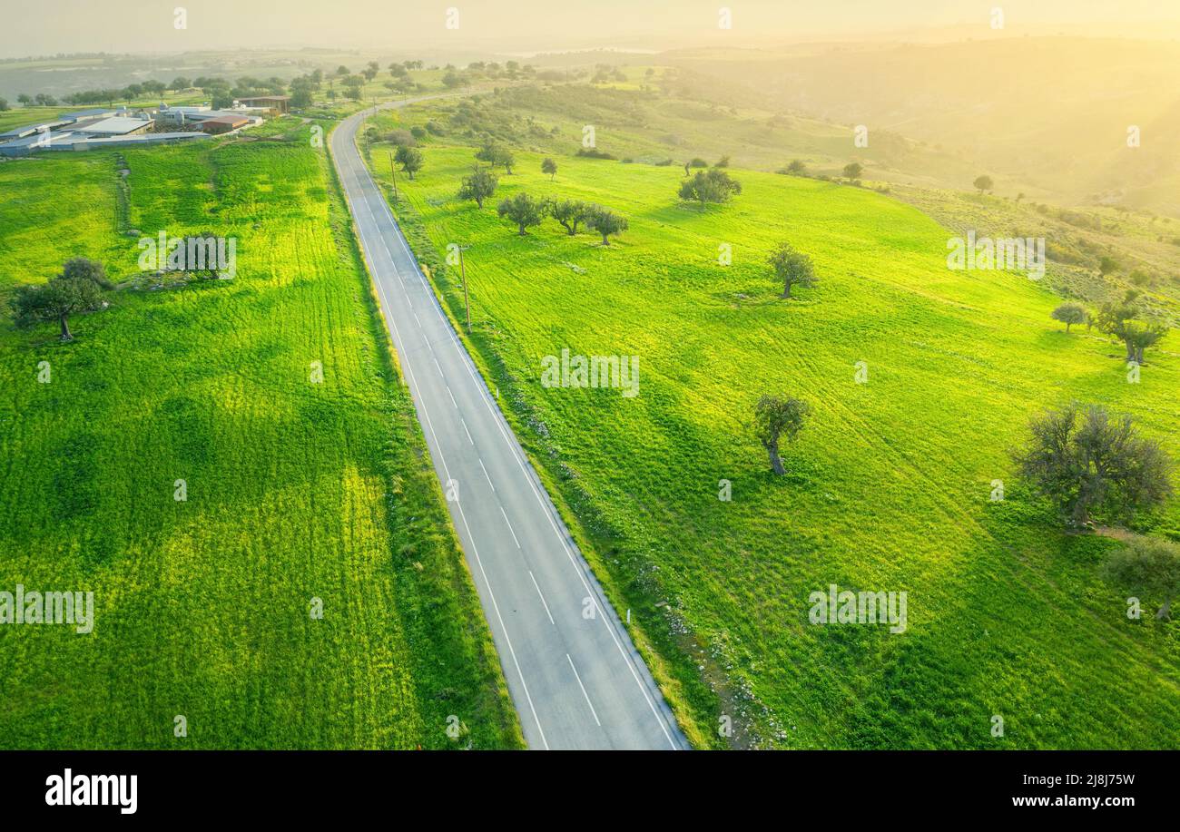 Green fields, empty road and farm at a distance. Drone countryside ...