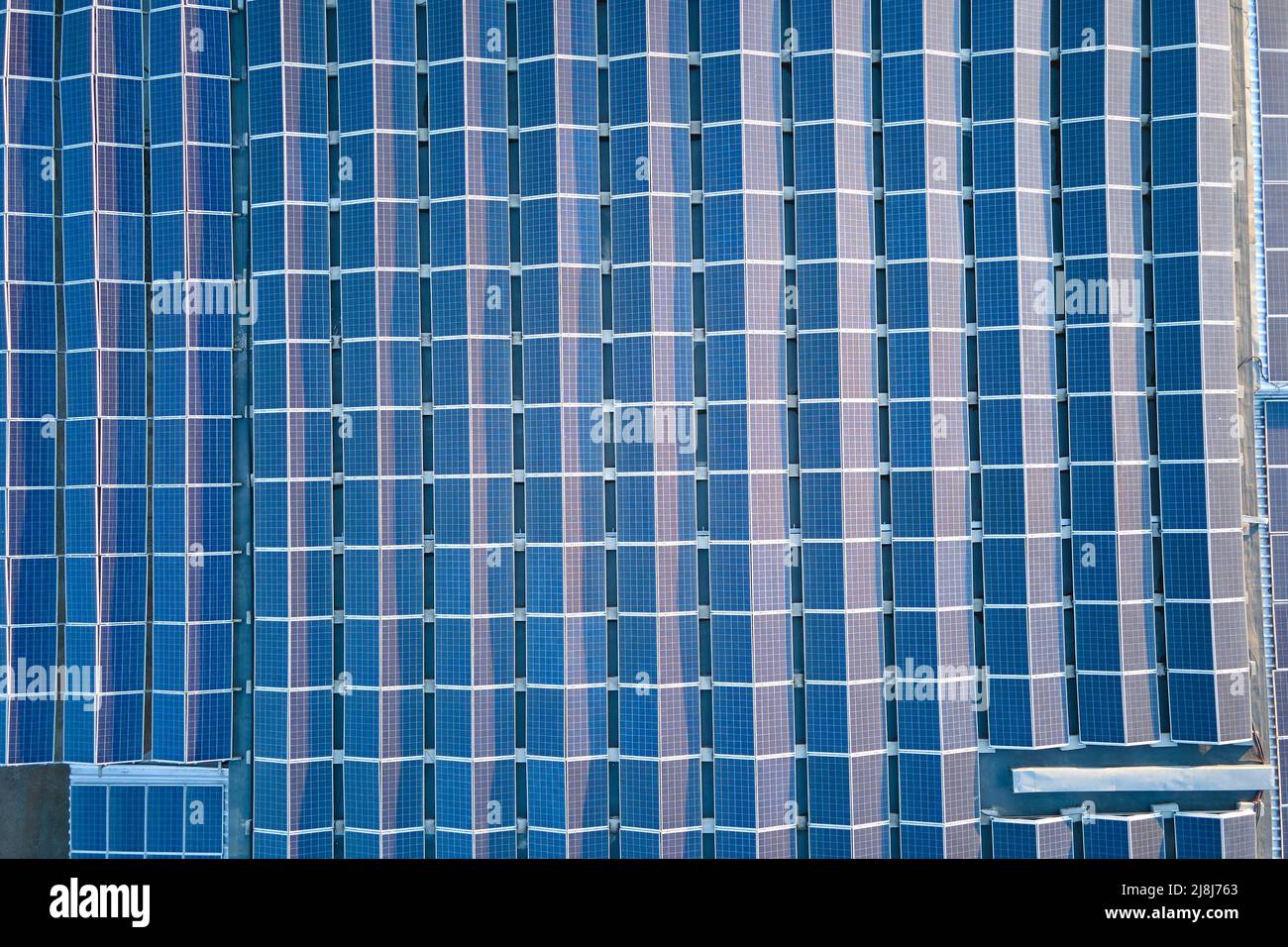 Aerial view of blue photovoltaic solar panels mounted on industrial ...