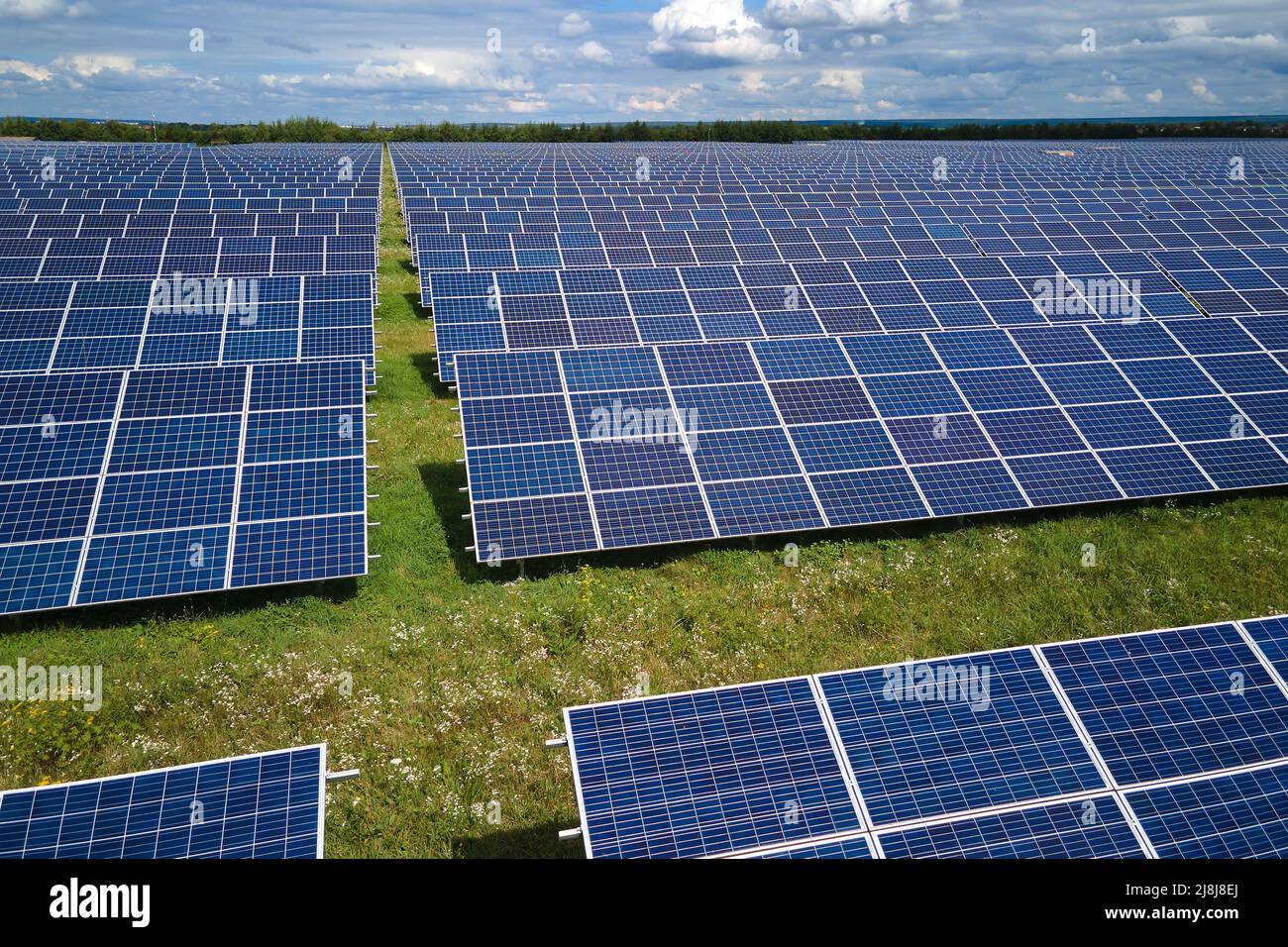 Aerial view of large sustainable electrical power plant with rows of solar photovoltaic panels ...