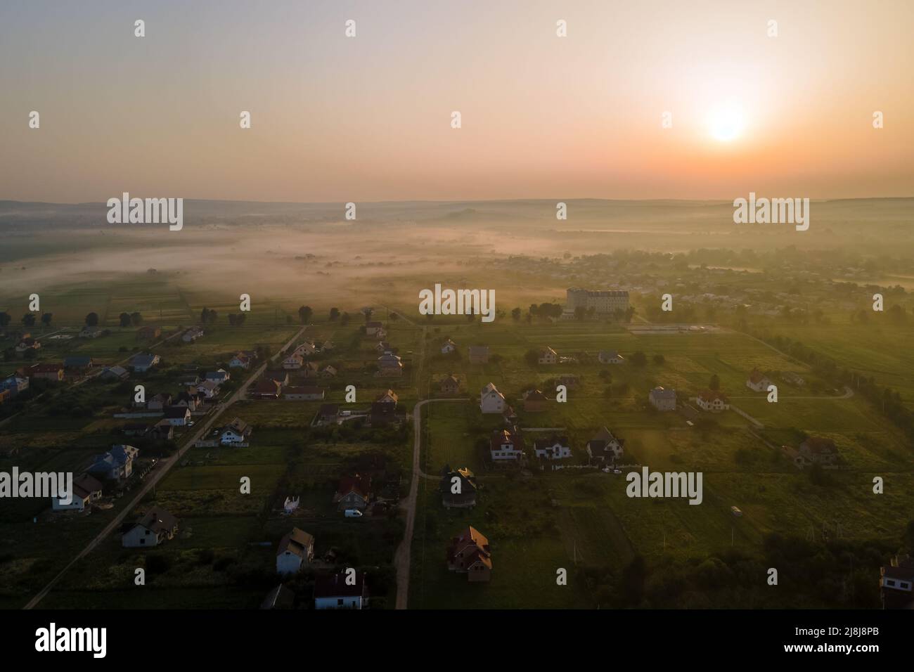 Aerial view of residential houses in suburban rural area at sunset ...