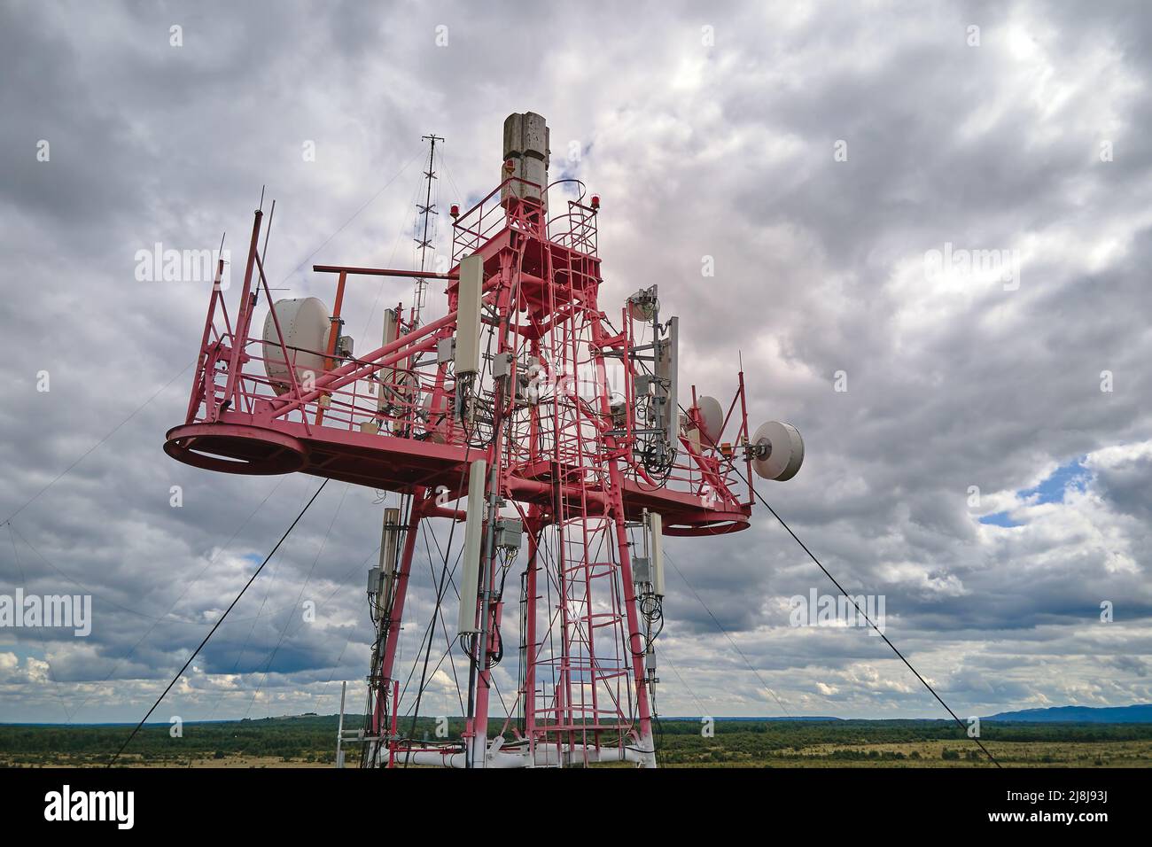Aerial view of telecommunications cell phone tower with wireless communication antennas for ...
