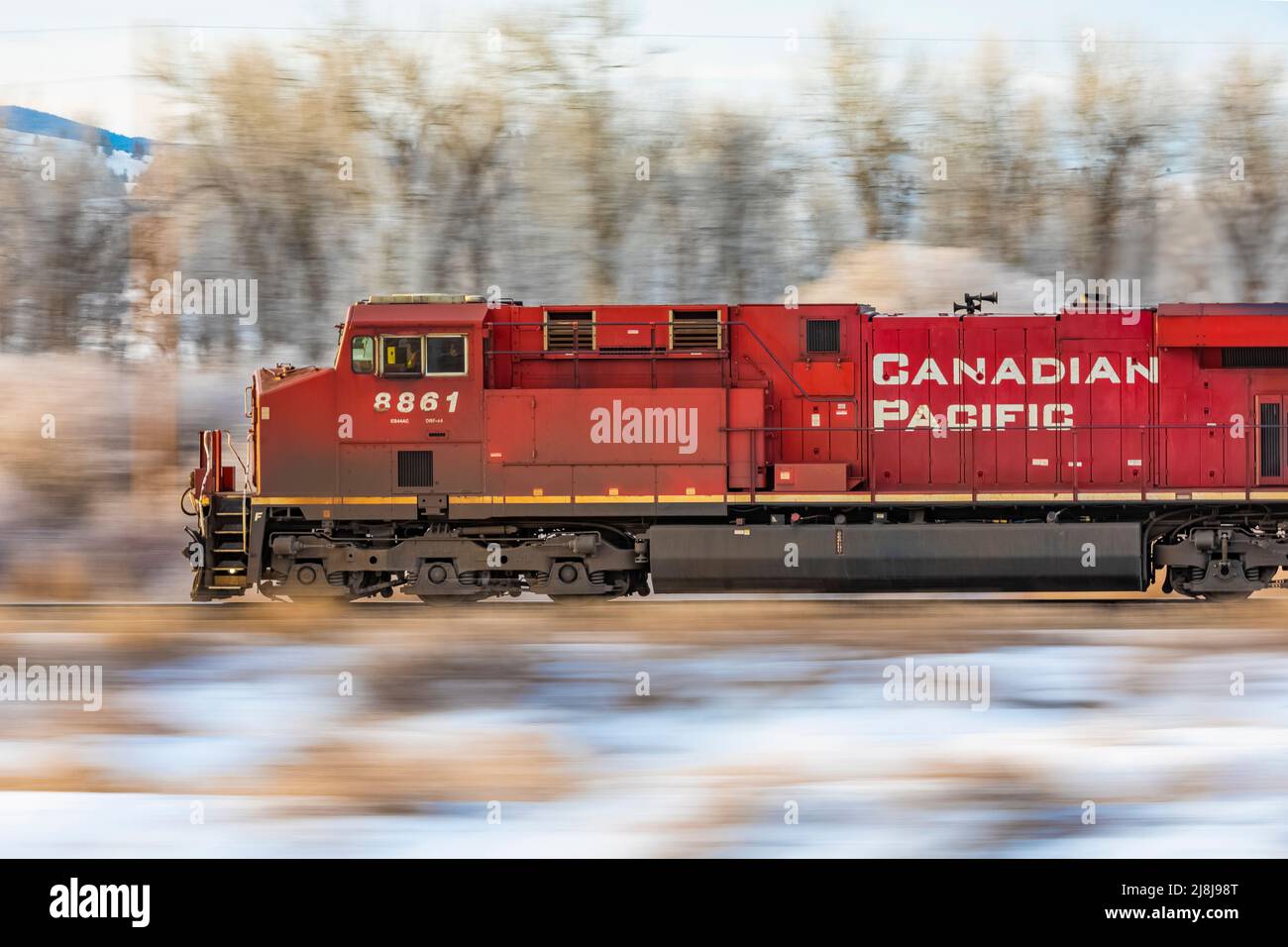 BNSF coal train fronted by a Canadian Pacific locomotive speeding through wintry Montana, USA ...