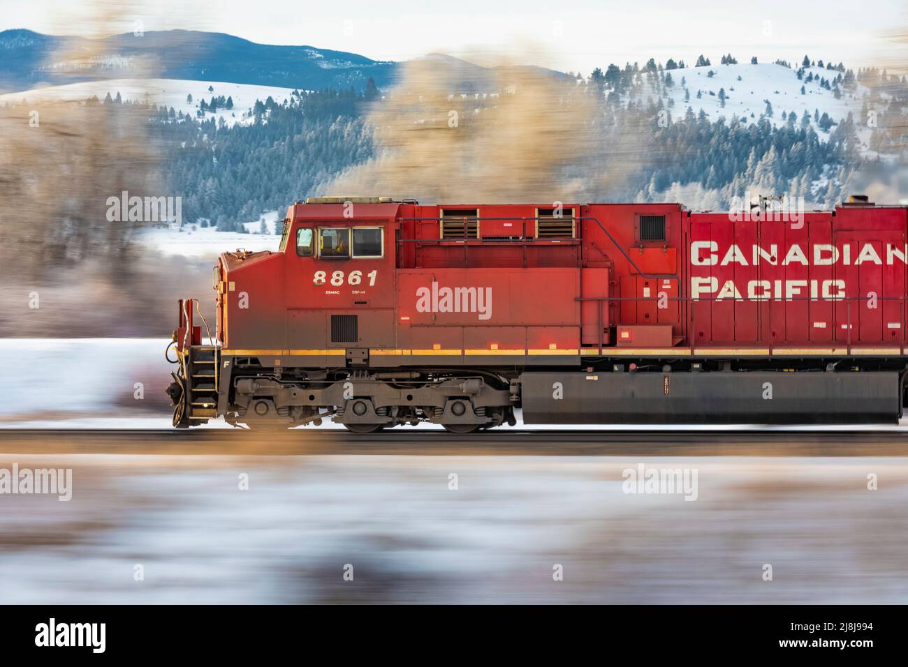 BNSF coal train fronted by a Canadian Pacific locomotive speeding through wintry Montana, USA ...