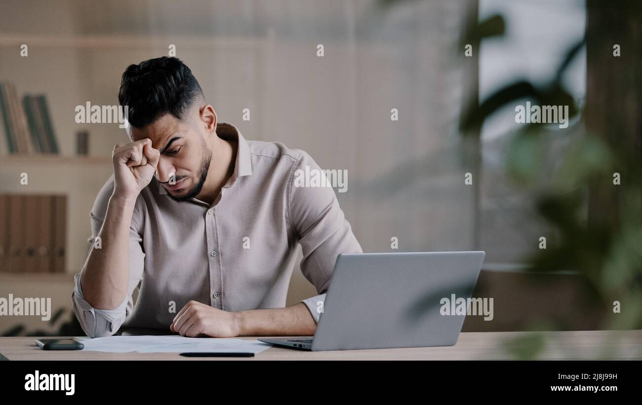 Unhappy shocked arabian male worker look at laptop screen feeling ...