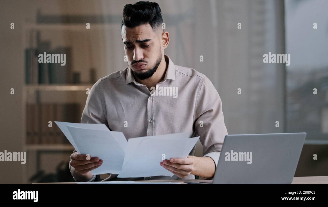 Frustrated hispanic young guy business man in office sadness accountant ...