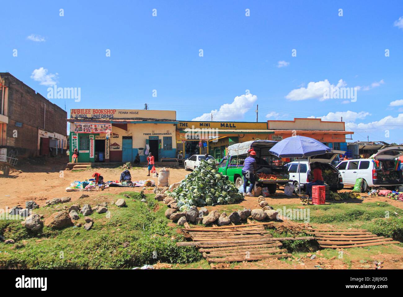 Market traders selling cabbage on dirt track of village street. Small ...
