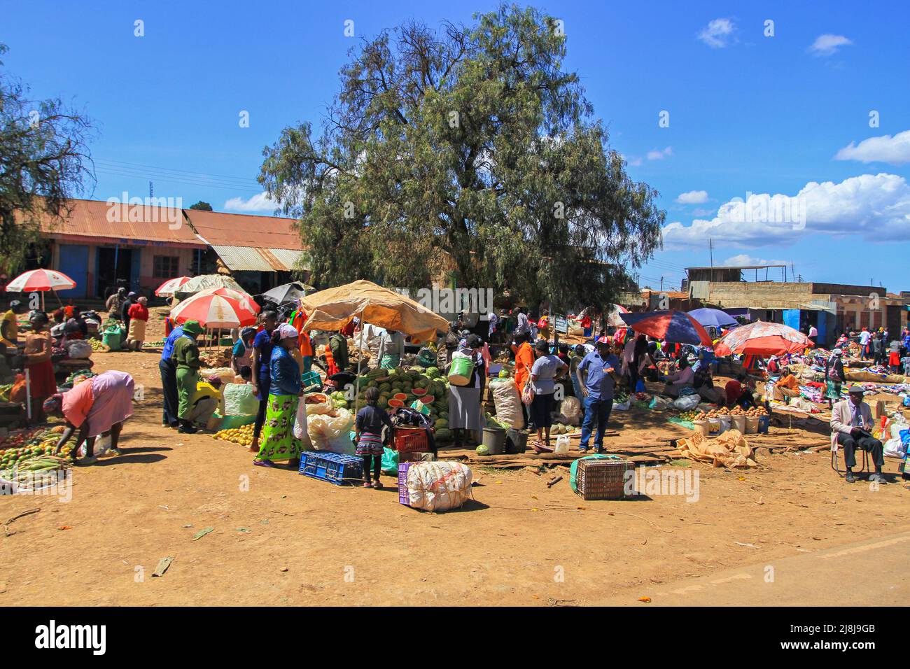 Busy market at side of road with people selling fruit and vegetables ...
