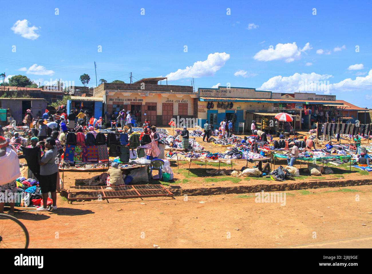 Market in Kenyan village with people selling clothes along side of road ...