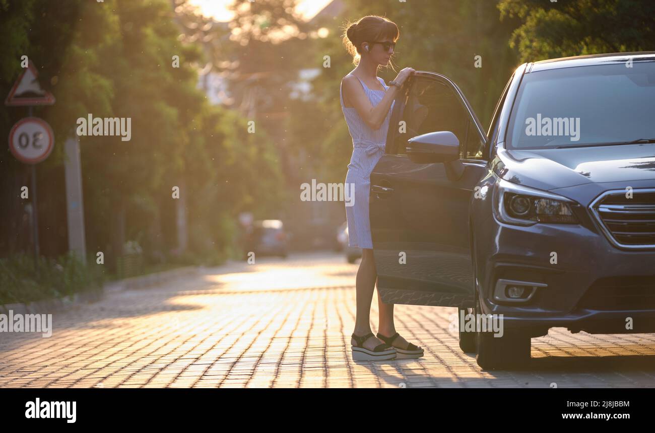 Young woman driver getting inside her car. Transportation and traffic ...