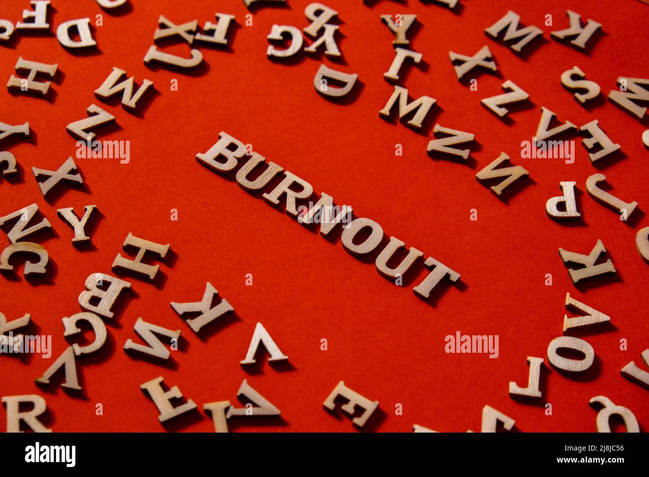 Word BURNOUT made out of wooden letters on bright red background ...
