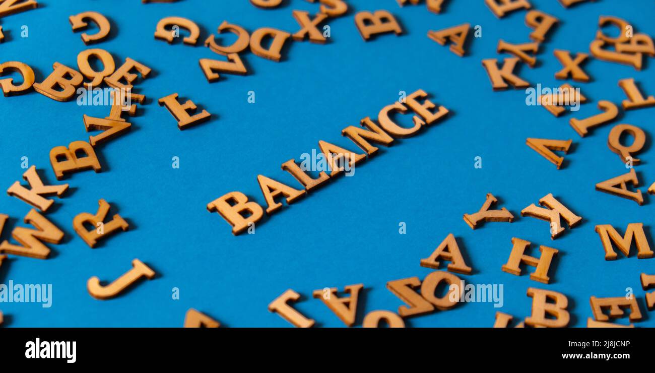 Word BALANCE made out of wooden letters on bright blue background ...