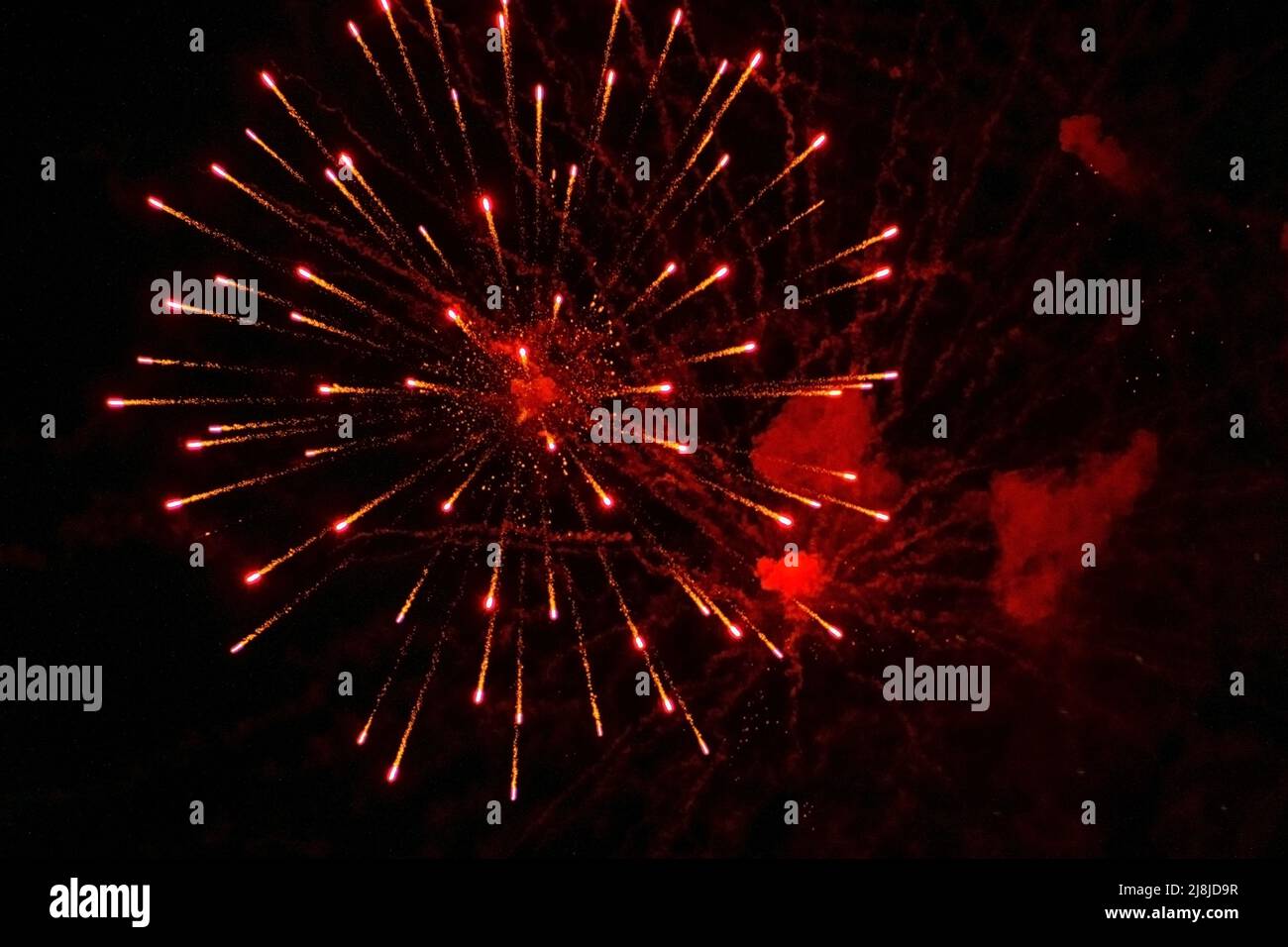 Beautiful festive fireworks, spherical, bright red, with haze. High ...